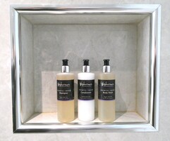 Uma prateleira com três produtos Wildnettle & Heather: Shampoo, Condicionador e Gel de Banho.