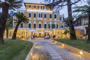 Hotel em estilo mediterrâneo, com área de estar externa e um caminho de cascalho.