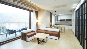 Uma sala de estar moderna com um sofá, uma mesa e uma varanda com vista.