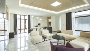 Uma sala de estar moderna com um sofá, uma mesa de centro e um espaço de jantar com cadeiras.