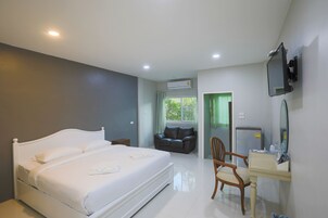 Quarto de hotel moderno com uma cama grande, uma escrivaninha com espelho e uma televisão.