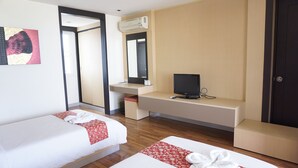 Quarto de hotel com duas camas, televisão, escrivaninha e um espelho grande.