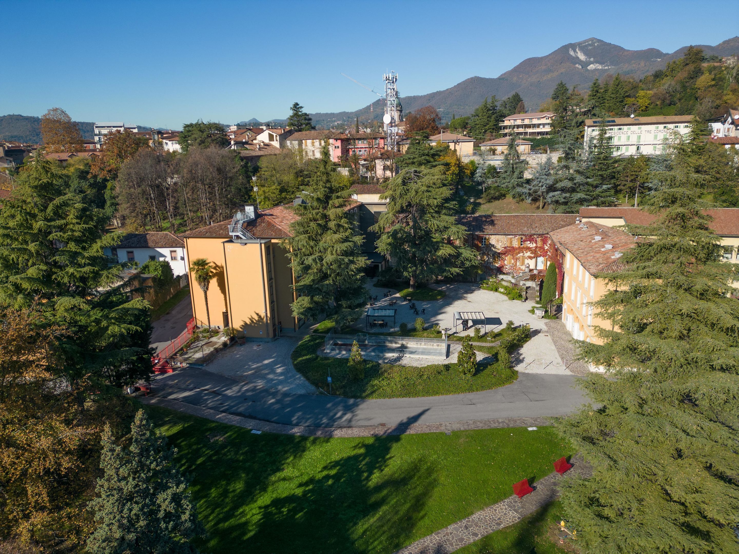 Zona residencial com um pátio central, rodeada por casas e árvores.