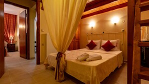 Quarto com cama, mesa de cabeceira, abajur e janela com cortinas.