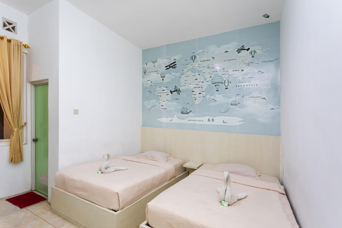 Quarto com duas camas, uma porta verde e um mural de mapa-múndi na parede.