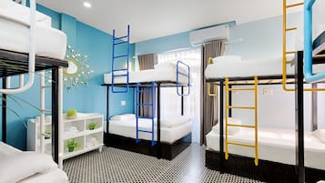 Quarto com beliche, parede azul, teto branco e chão estampado.