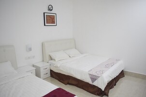 Quarto com uma cama, mesa de cabeceira e cômoda.