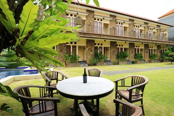 Um hotel com piscina, área de estar ao ar livre e um jardim bem cuidado.