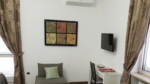 Sala de estar com dois sofás, uma televisão e uma mesa pequena.