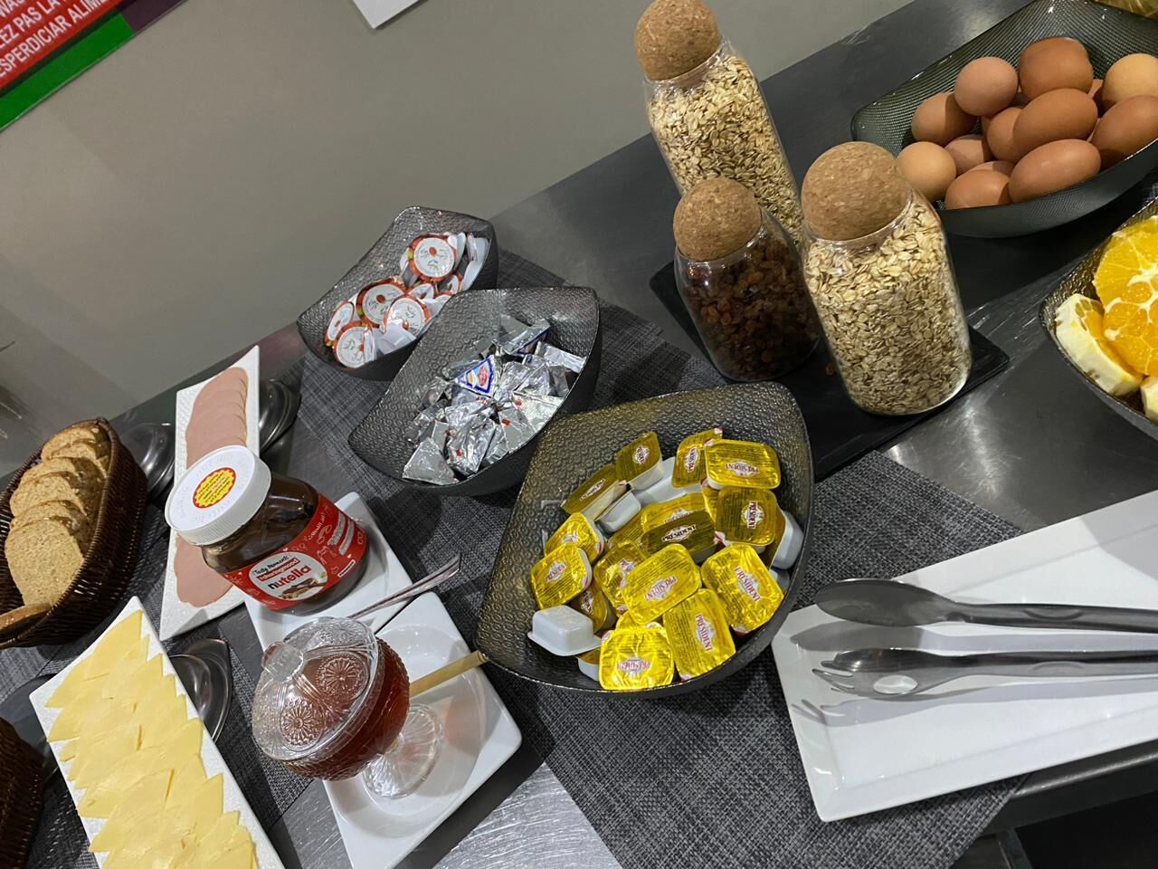 Um buffet de café da manhã com diversos alimentos e acompanhamentos.