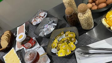 Um buffet de café da manhã com diversos alimentos e acompanhamentos.