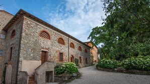 Um edifício de pedra com janelas em arco e um caminho de cascalho que leva até ele.