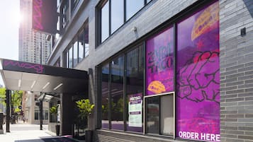 Um edifício com grandes janelas e uma placa com a inscrição "Zombie Taco".