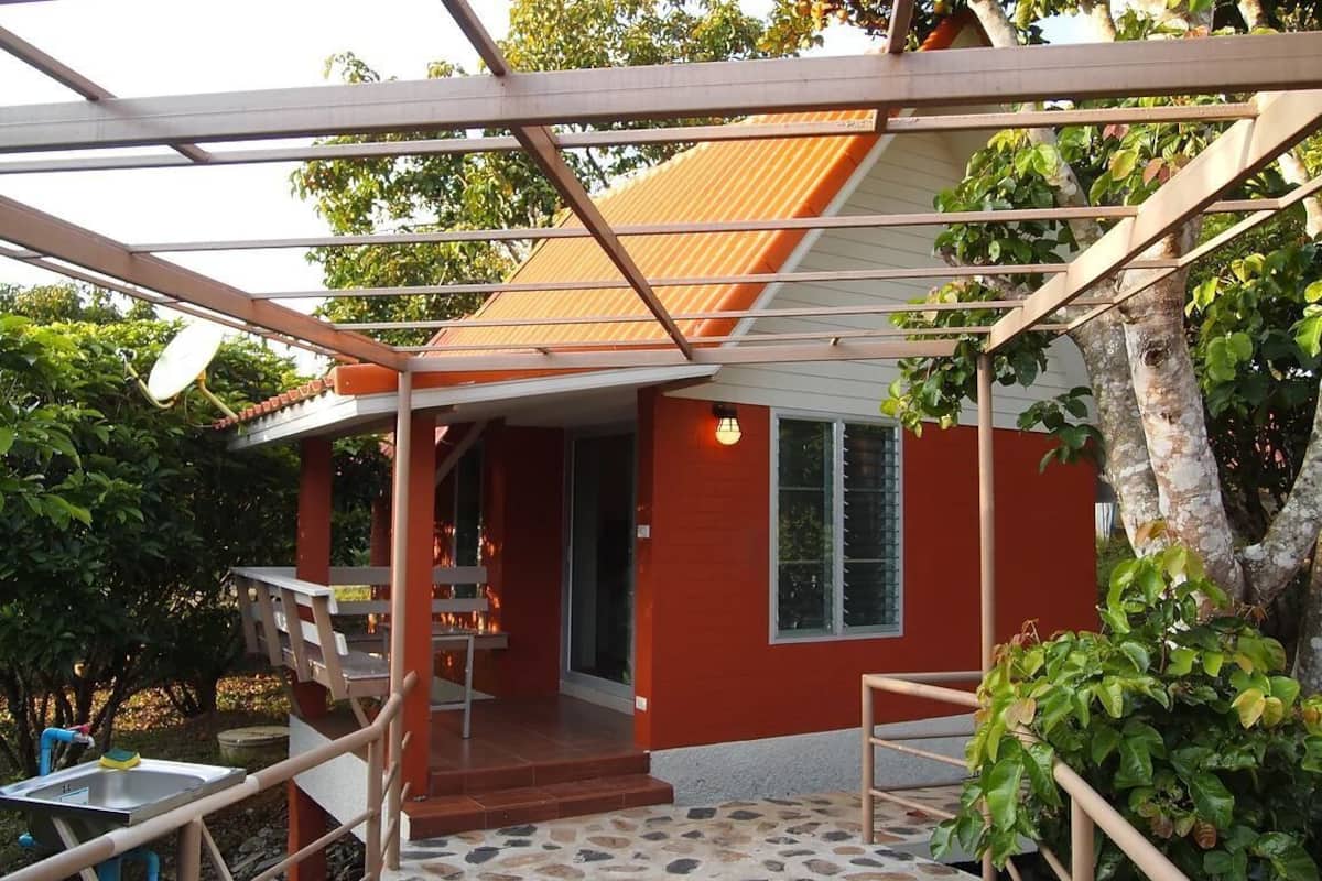Um edifício vermelho com um alpendre coberto e uma escadaria que leva à porta.