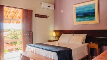 Quarto com cama, mesa de cabeceira e um quadro na parede.