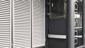 Porta fechada com puxador de metal e placa com a inscrição 'HousInn'.