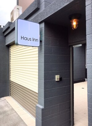 Porta de garagem fechada de um edifício com uma placa que diz 'Haus Inn'.
