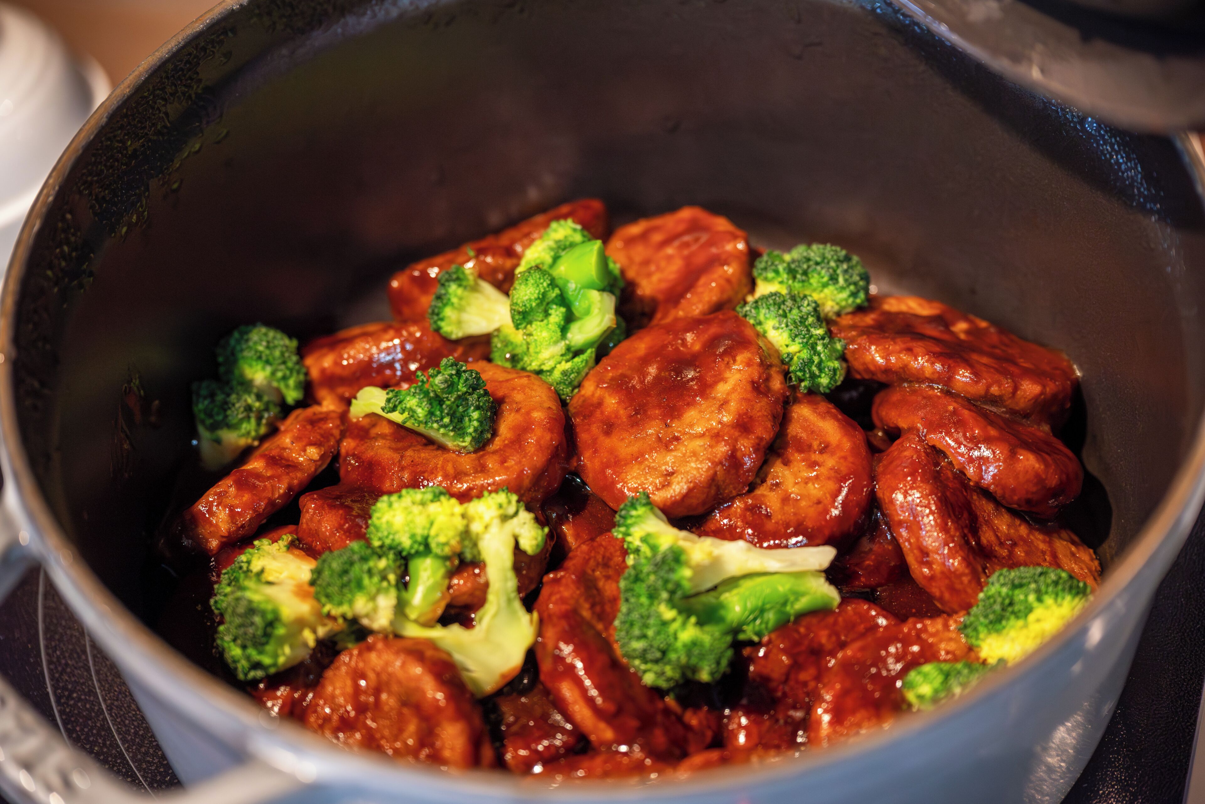 Uma tigela de comida com carne e brócolis.
