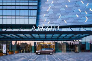 Um edifício moderno com fachada de vidro e a inscrição “ASCOTT” em destaque.
