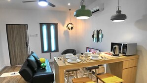 Uma cozinha moderna com ilha de madeira, banquetas de bar e uma mesa de jantar posta para quatro pessoas.