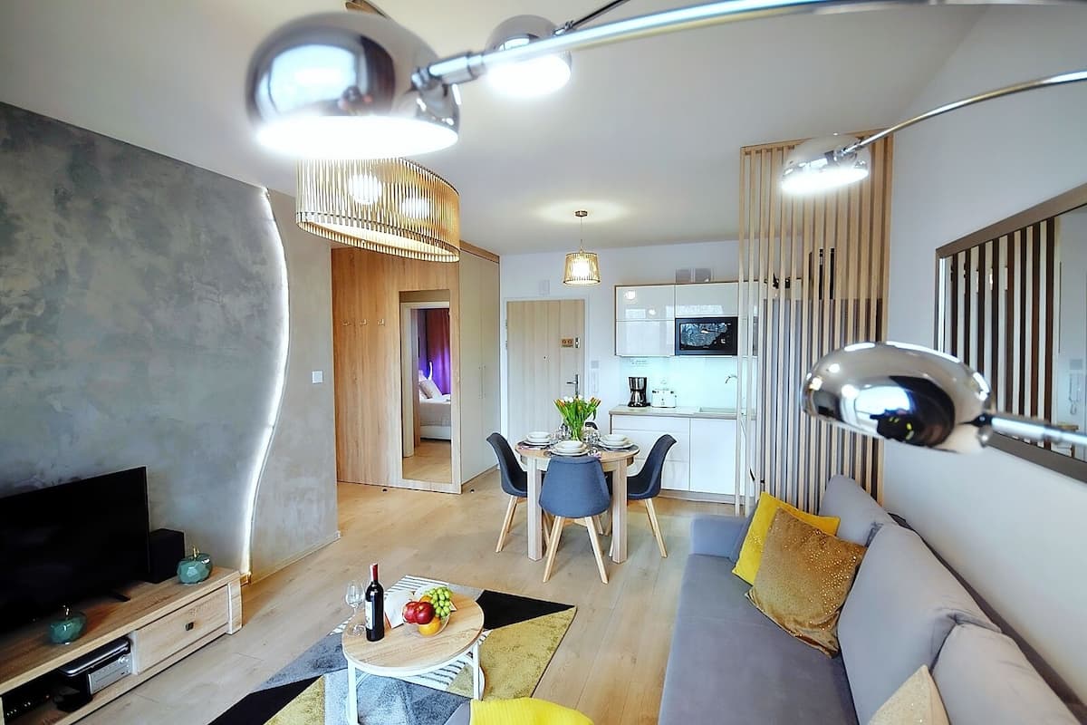 Uma sala de estar moderna com televisão, sofá e área de jantar.