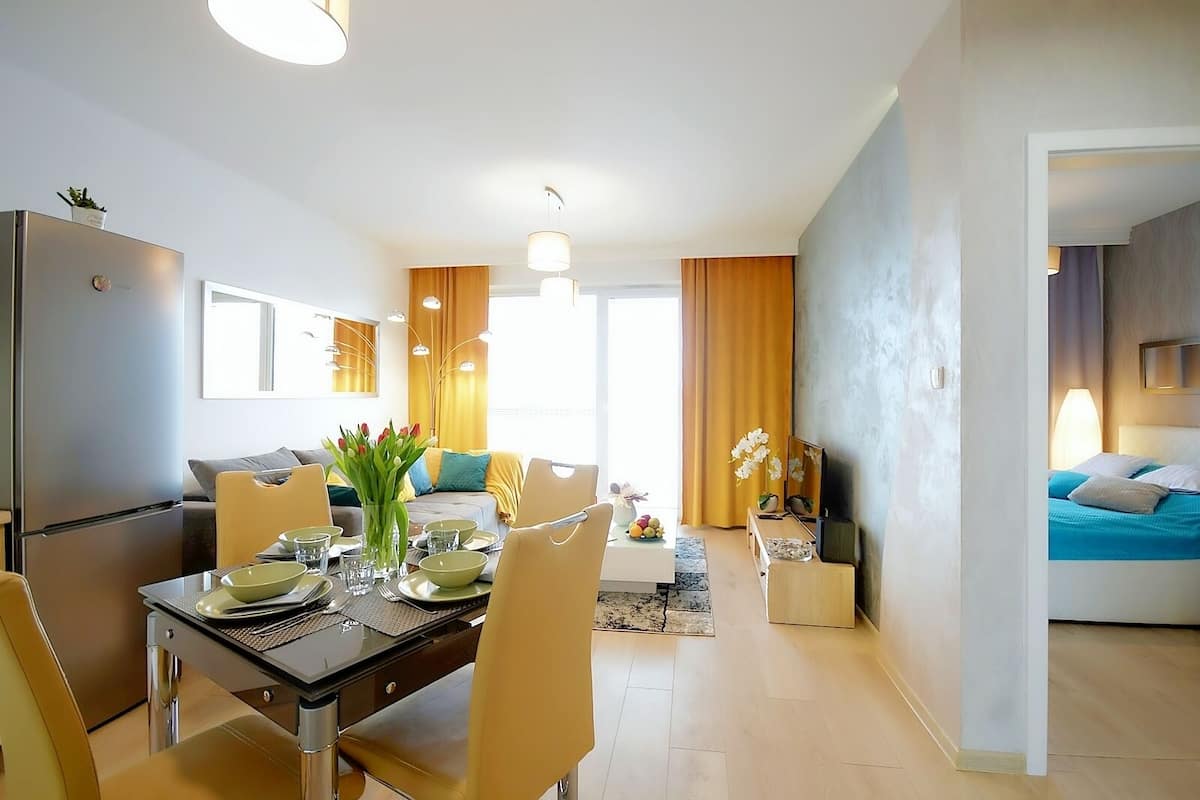 Uma sala de estar moderna com área de jantar, cozinha e quarto.