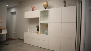 Cozinha moderna com armários brancos, um globo e uma planta no balcão.