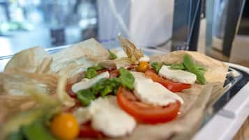 Close-up de uma salada fresca com tomate, mussarela e manjericão em um prato.