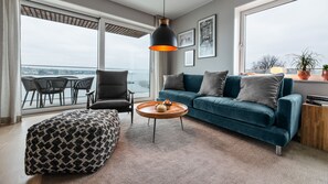 Suíte, 1 quarto, sacada, vista para o mar | Área de estar | TV