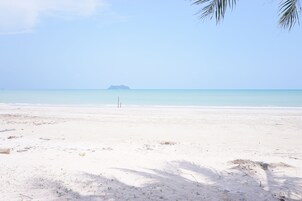 Na praia, espreguiçadeiras, guarda-sóis, toalhas de praia