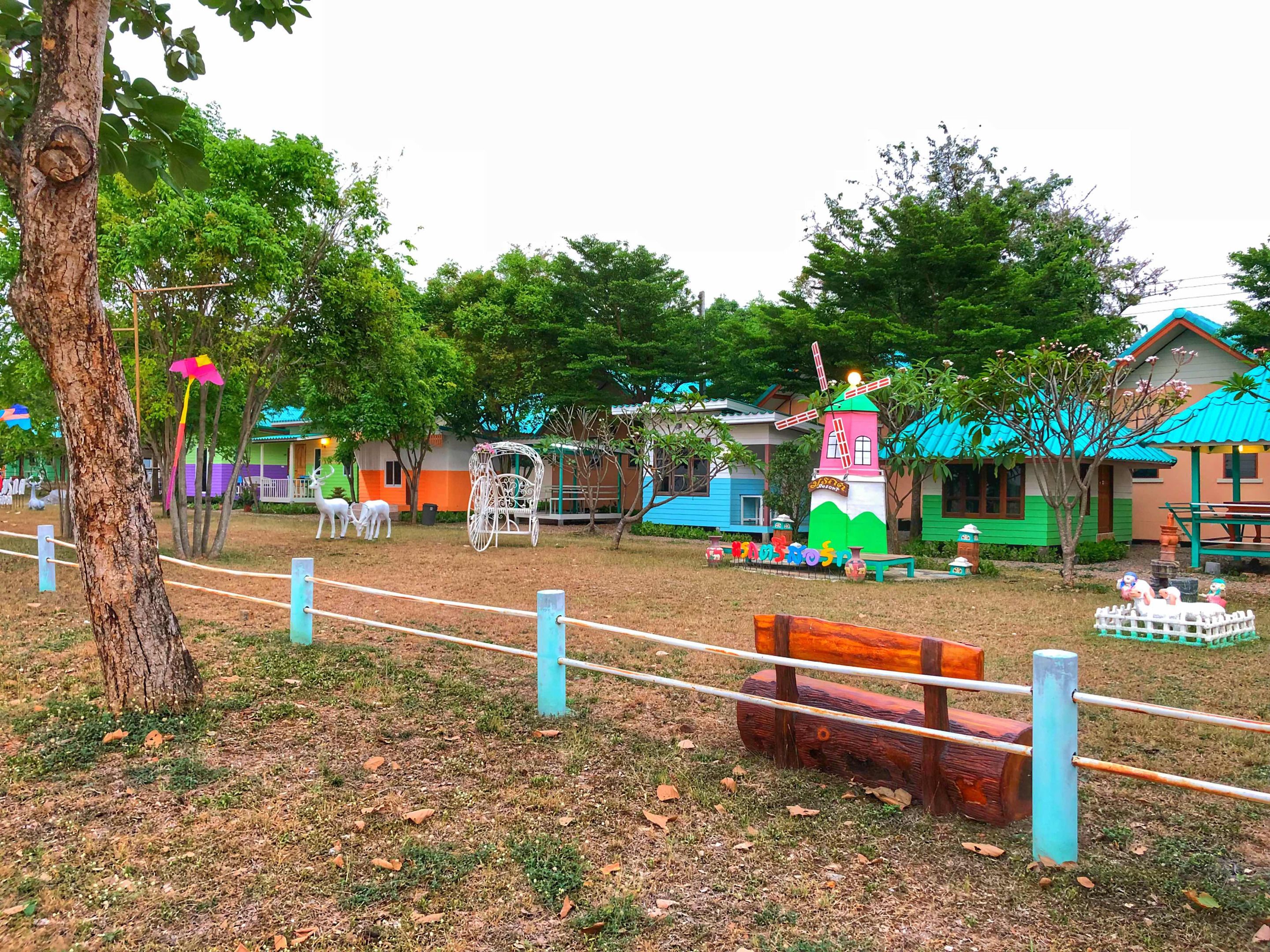 Uma área de recreação infantil com balanço, escorrega e uma casinha.