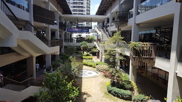Um átrio com vários níveis, um jardim central, varandas e lojas.