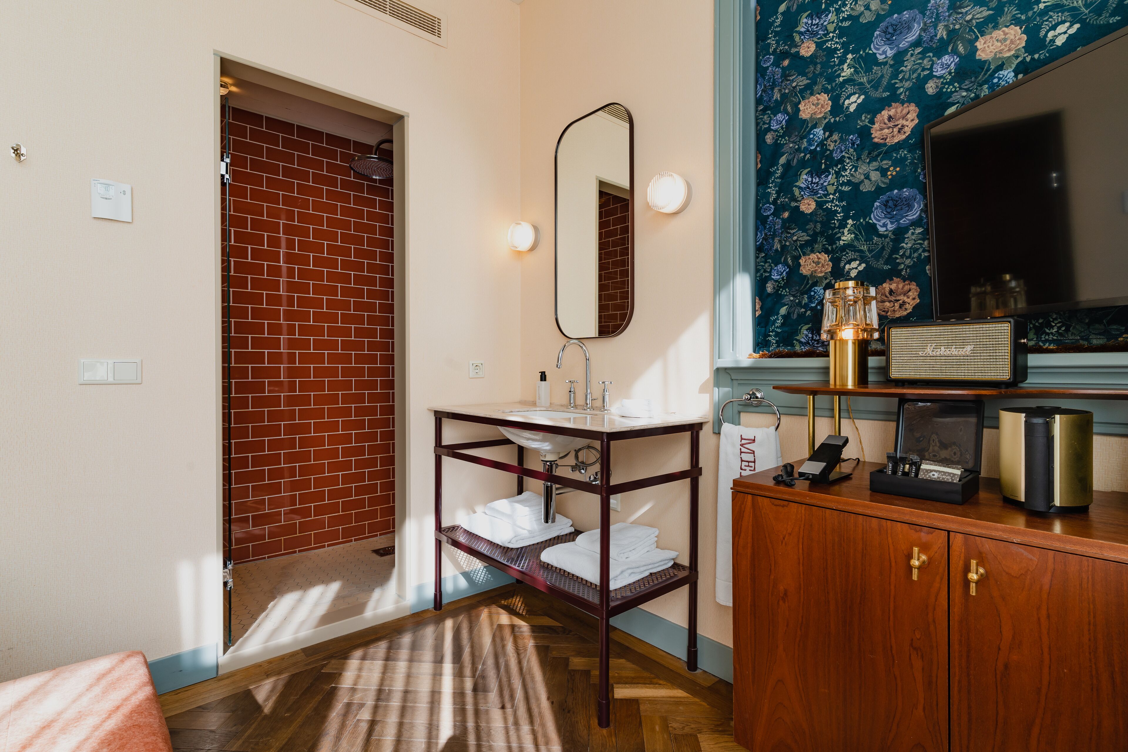 Casa de banho com lavatório, espelho e toucador com rádio e artigos de higiene pessoal.