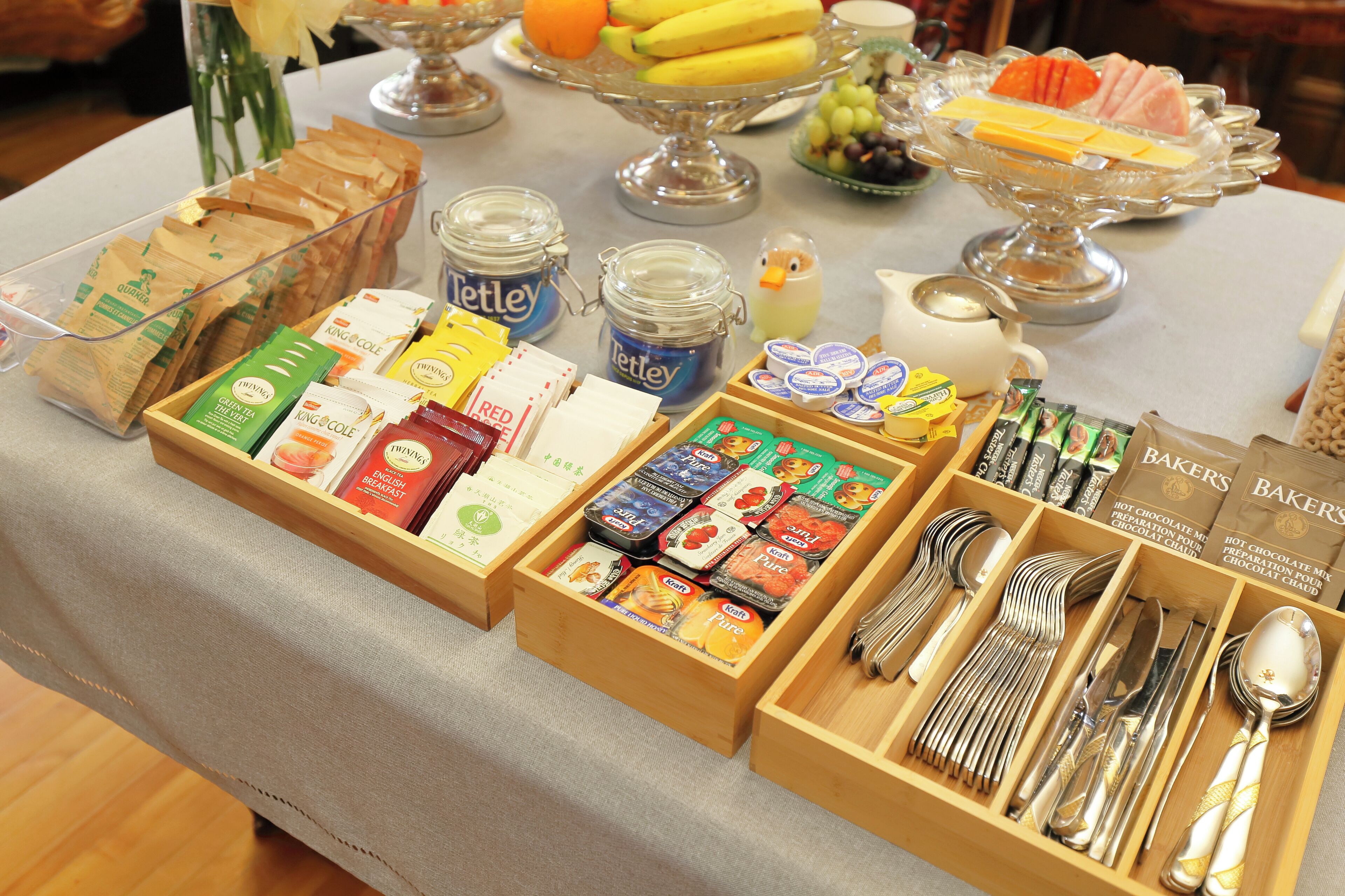 Uma mesa de buffet com diversos alimentos, acompanhamentos e utensílios.