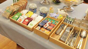 Uma mesa de buffet com diversos alimentos, acompanhamentos e utensílios.