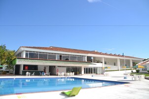 Um edifício moderno com piscina, área de estar ao ar livre e um terraço coberto.