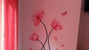 Paredes com um desenho floral, uma tomada e um cabo.