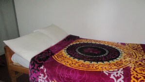 Uma cama com um cobertor estampado e duas almofadas.