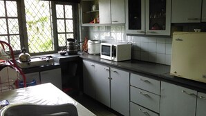 Cozinha com armários cinza, micro-ondas e geladeira.