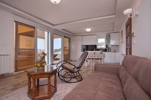 Apartamento Deluxe, 1 quarto, vista para o mar | Sala de estar | Televisor