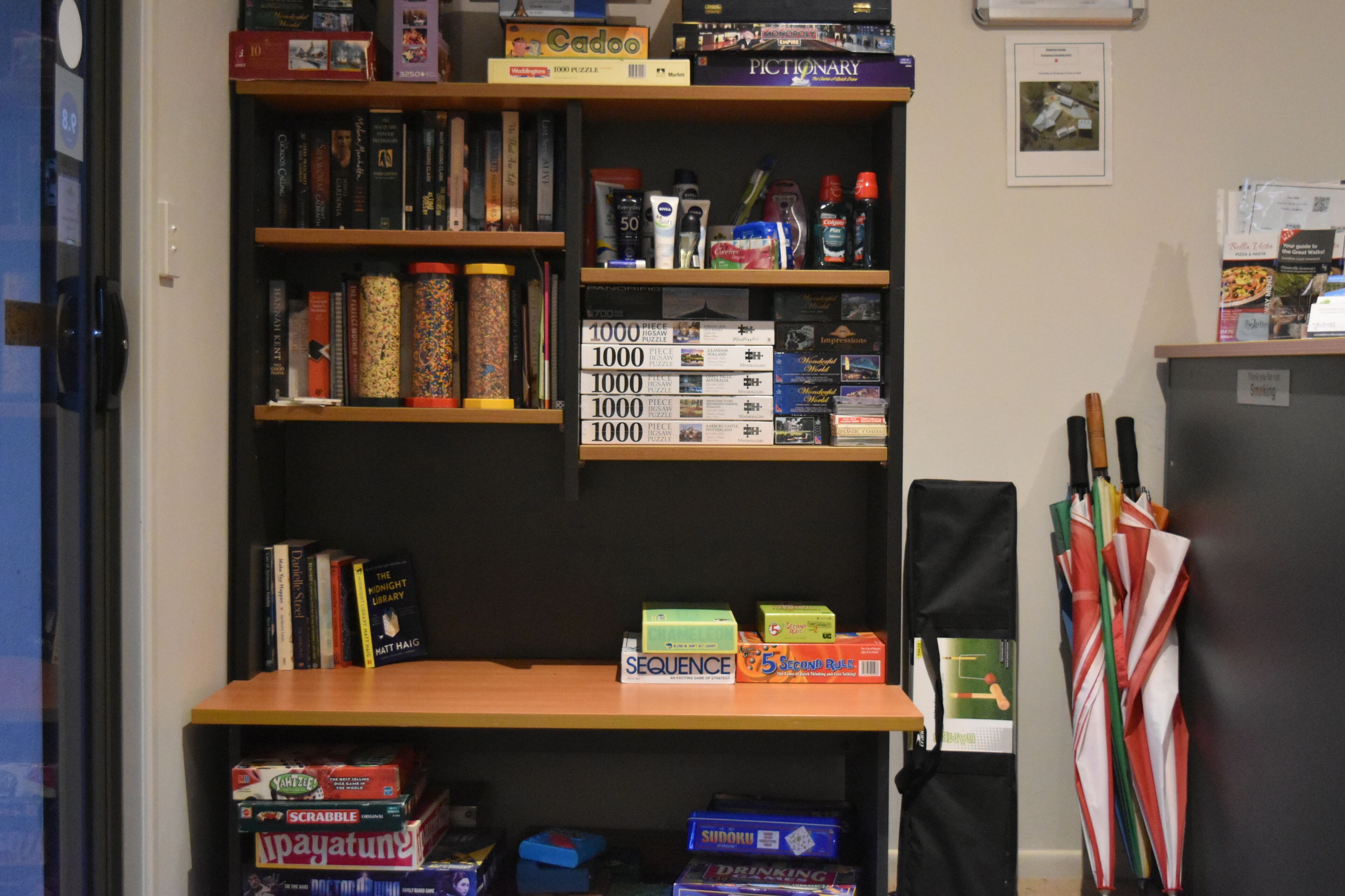 Quarto com uma estante cheia de jogos de tabuleiro e quebra-cabeças.
