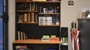 Quarto com uma estante cheia de jogos de tabuleiro e quebra-cabeças.