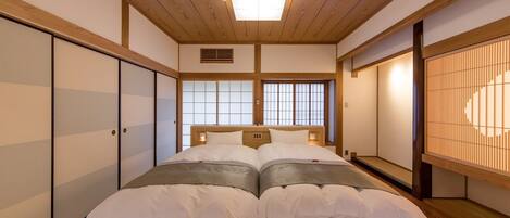 Quarto japonês tradicional com teto de madeira, portas deslizantes e piso de tatame.