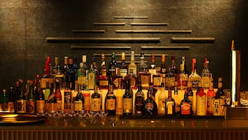 Um bar com várias garrafas de álcool e copos.