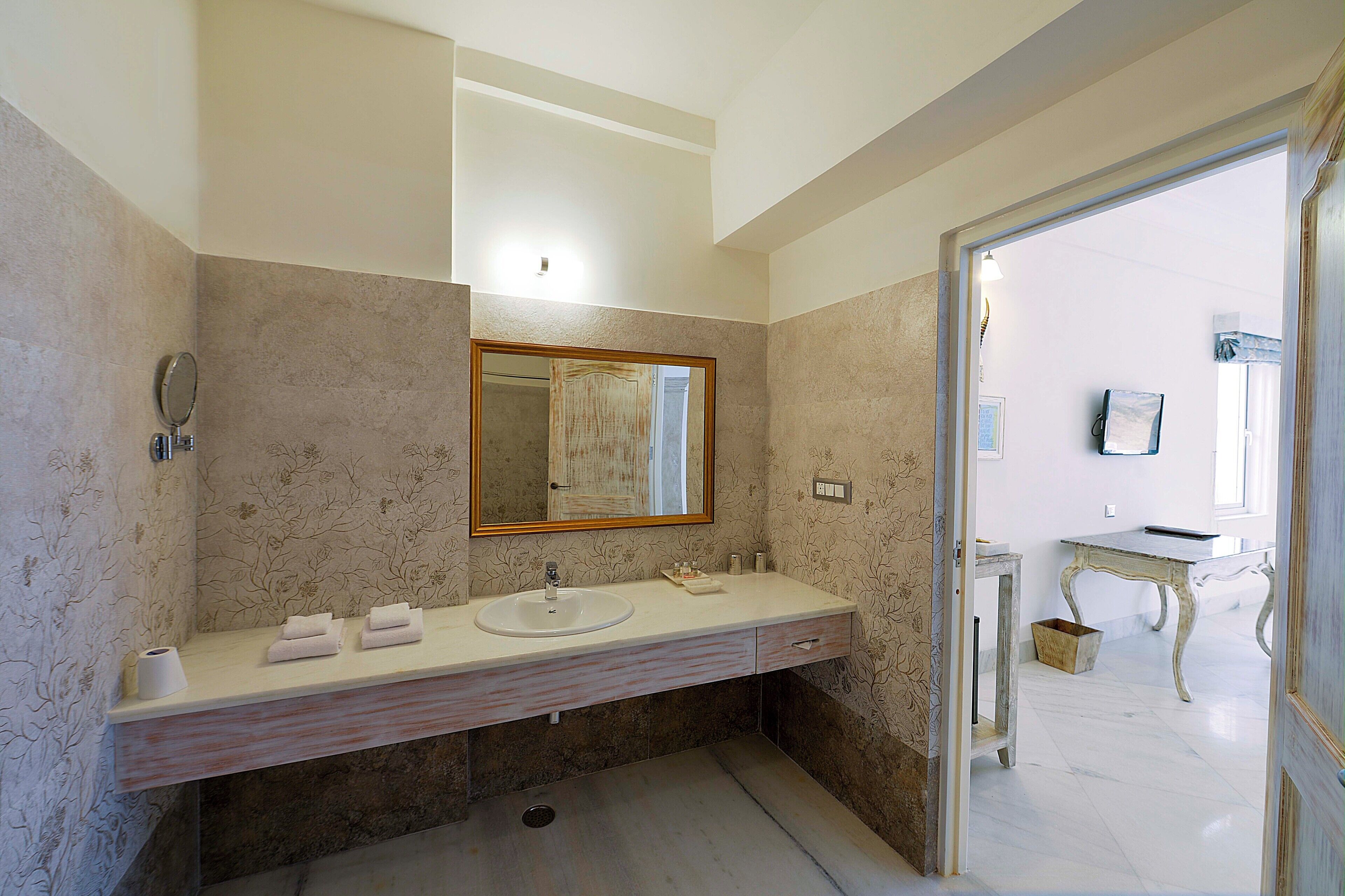 Casa de banho com duas pias, um espelho e um porta-toalhas.