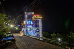 Um edifício bem iluminado com um letreiro de neon que diz 'Motel Bliss Tall'.