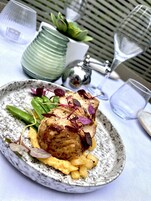 Um prato com carne, vegetais e batatas.