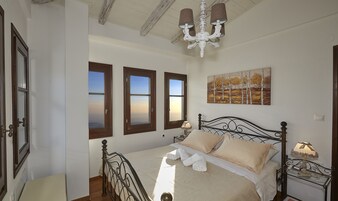 Quarto com cama, luminária e pintura na parede.