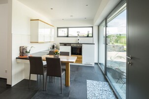 Uma cozinha moderna com área de refeições, com uma janela grande e vista para o exterior.