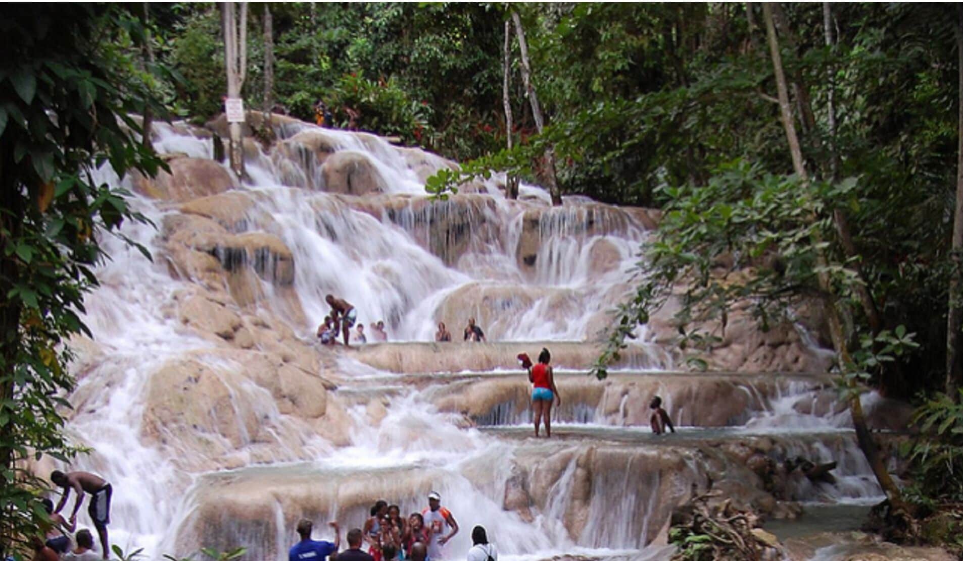 Uma cascata em vários níveis com pessoas se divertindo na água.